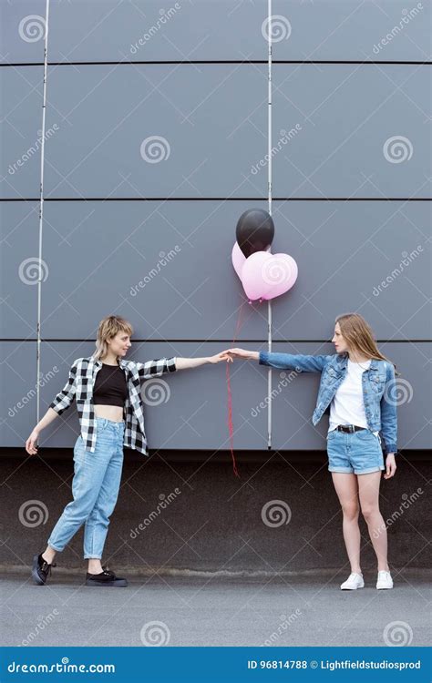 Happy Lesbian Couple Holding Hands With Air Balloons Outdoors Stock