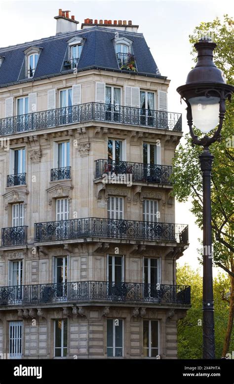 The Facade Of Traditional French House With Typical Balconies And