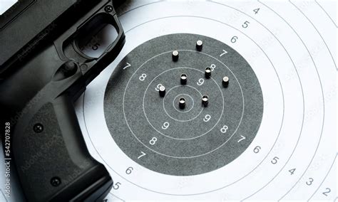 Black Air Gun Pellet Gun Laying On A Paper Shooting Target Next To A