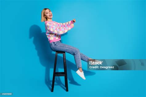 황홀한 소녀 입고 풀오버 의자에 앉아 보이지 않는 스티어링 휠 고립 된 파란색 배경의 전체 길이 측면 프로필 사진 여자에 대한 스톡 사진 및 기타 이미지 Istock