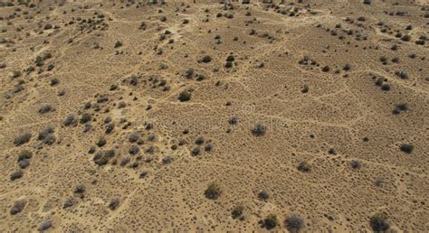 Aerial View Of An Arid Desert Terrain Dotted With Sparse Vegetation
