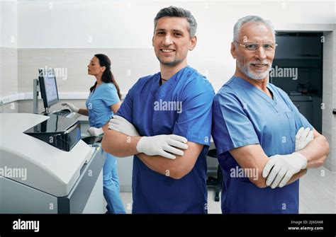 Laboratory Technicians Standing Against Backdrop Of Medical Lab While