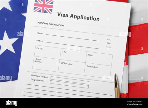 Immigration To Usa Visa Application Form And Pen On Flag Flat Lay