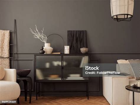 모의 포스터 프레임 유리 사이드 보드 말린 꽃이있는 꽃병 모듈 식 소파 나무 바닥 어두운 벽 및 개인 액세서리가있는 거실