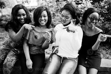 Group Of Four African American Girls Sitting Outdoor And Showing