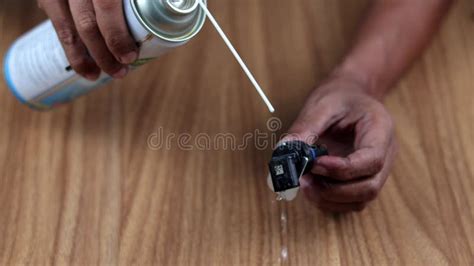 Close Up Hand Spray The Transmission Speed Sensor With Contact Cleaner