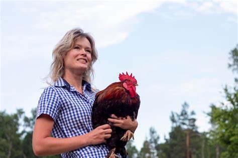 Premium Photo Side View Of Young Woman Holding Rooster
