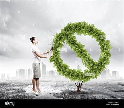 Young Attractive Businesswoman Cutting Plant In Shape Of Prohibition