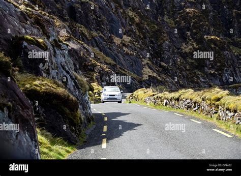 Auto On Narrow Two Way Road Descending The Conor Pass From Dingle Town