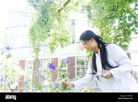 Young Female Scientist With Digital Tablet Outside Laboratory Selecting