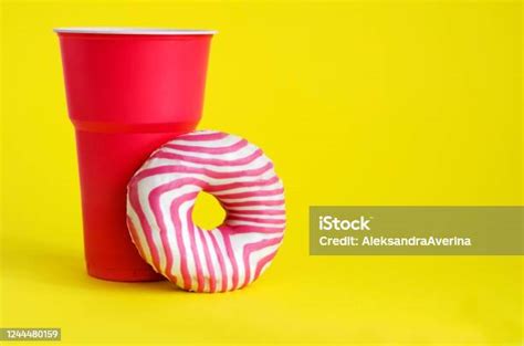 노란 배경에 플라스틱 분홍색 유리 옆에도 도넛이 서 있습니다 정크 푸드 정크 플라스틱 요리의 개념 수평 배경 부드러운 초점 0명에 대한 스톡 사진 및 기타 이미지 Istock