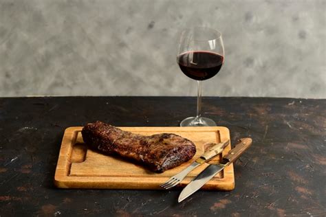 Premium Photo Roasted Beef Ribs With A Glass Of Red Wine Presented On