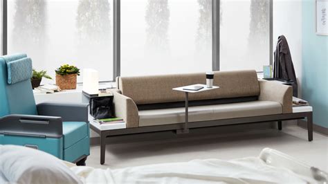 Surgeon And Patient Are Sitting On Sofa In Clinic Stock