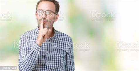 입술에 손가락으로 조용히 하 라는 고립 된 배경 위에 안경을 쓰고 잘생긴 중세 우아한 수석 비즈니스 사람 침묵 그리고 비밀
