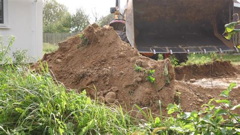 A Construction Site Characterized By A Large Dirt Pile And Heavy