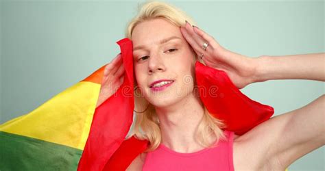 Transgender Blond Man Holding Rainbow Flag On The Plain Background