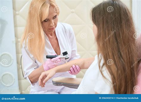 Beautiful Woman Dermatologist Examines Skin On Girl Hand With