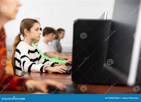 jovem garota aprendendo a usar o computador pessoal durante a aula foto