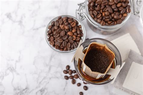 드립 커피 백과 커피 원두 컵에 양조용 분쇄 커피 종이 봉지 드립 커피 필터 포장 대리석 질감 테이블에 구성입니다 모캡 음료를