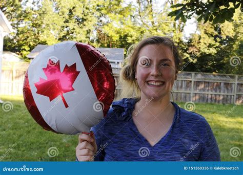Young Woman Enjoying The Canada Day Holiday Holding A Canadian Flag