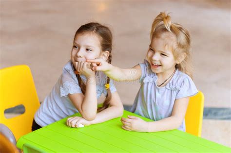 Deux Soeurs S asseyant à La Table Verte Image stock Image du gosse joyeux