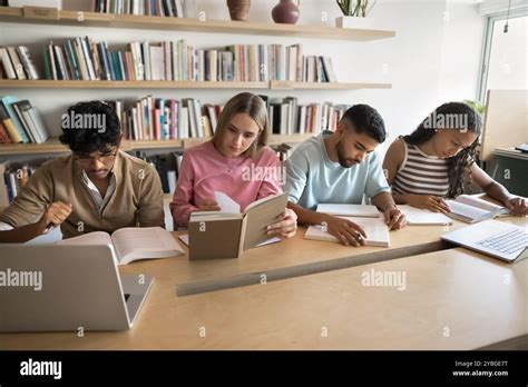 Multiethnic College Students Visiting Library Reading Textbooks Stock