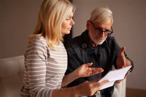 Debt To Pay Bills Alarmed Mature Husband And Wife With A Letter Stock