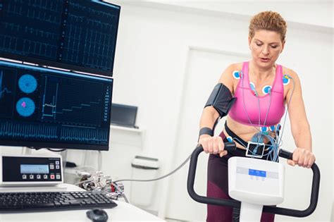 Mature Adult Woman Riding And Exercise Bike During Biometric Testing