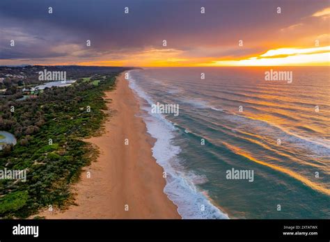 Aerial View Over Waves Crashing On A Beach Under A Dramatic Coloured