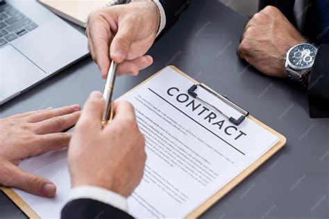 A Man Signing Contract On A Clipboard Premium Photo