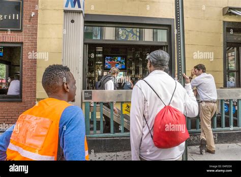 Diverse Group Of Guys Standing On New York Sidewalk Outside Corner Bar