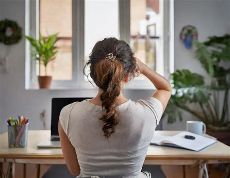 Premium Photo Back View Of A Person In A Home Office Slouched Over A