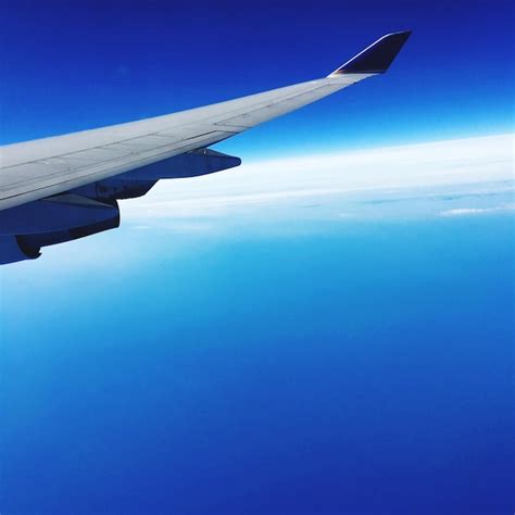 Premium Photo Airplane Wing Against Blue Sky