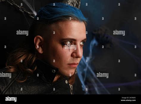 Teen Alt Boy With Blue Hair And Shaved Head Dressed In Black On Dark