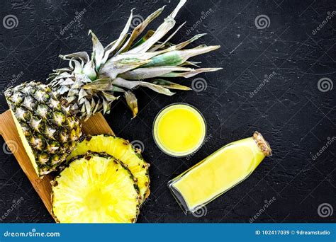 Freshly Squeezed Pineapple Juice Near Fruit Slices On Black Background