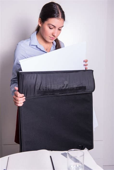 Female Engineer Is Taking Drawings Out Of A Big Folder Stock Image