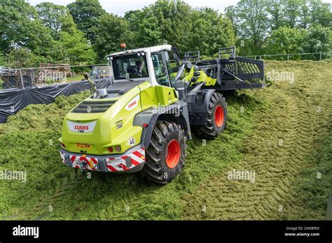 Working On A Silage Clamp With A Claas Laoder Using A Big Loader Grab To Move The Grass And