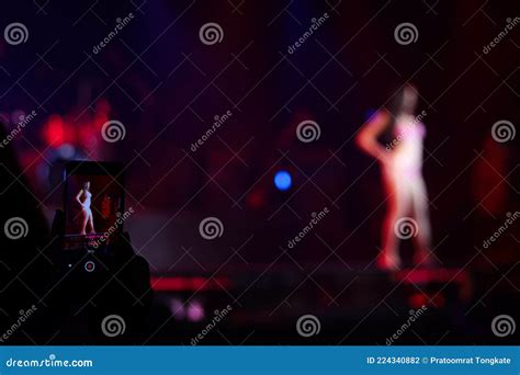 Audience Taking Photo And Recording Video Of Woman Dancing On Stage