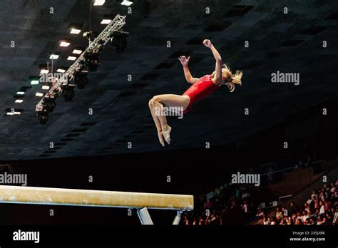 exercise on balance beam gymnastics, female gymnast perform backward somersault landing on floor ...