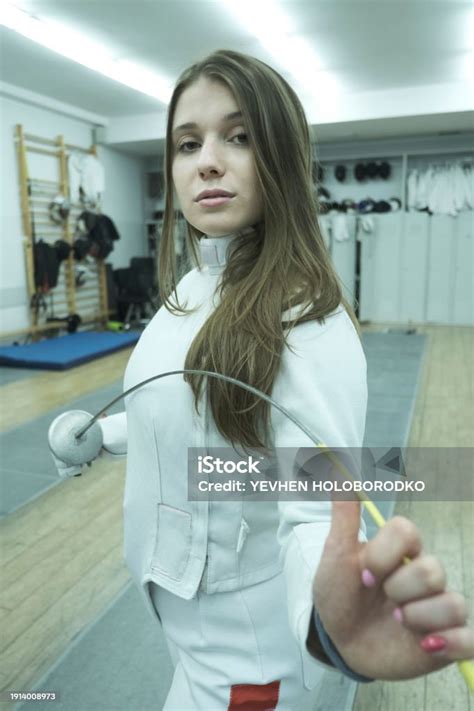 Professional Fencer Girl With Fencing Mask And Rapier Training In Hall