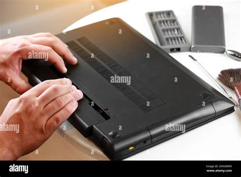 Repairmans Hands Removing The Power Battery From The Laptop Computer