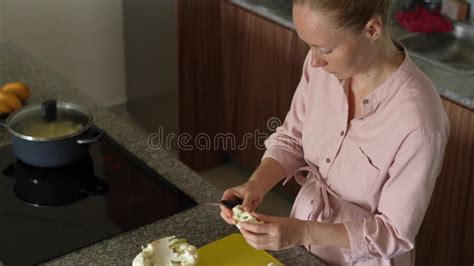 A Young Woman Is Cooking Food In The Kitchen Focusing On Preparing A