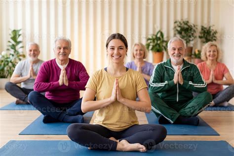 Young Instructor And Seniors In Yoga Pose With Prayer Hands 78655013