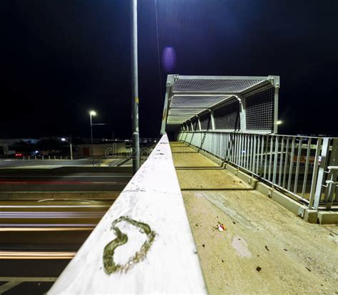 Night View Of A Pedestrian Walkway That Passes Over A Highway Stock