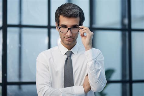 Premium Photo Serious Businessman Corrects Glasses Portrait In Office