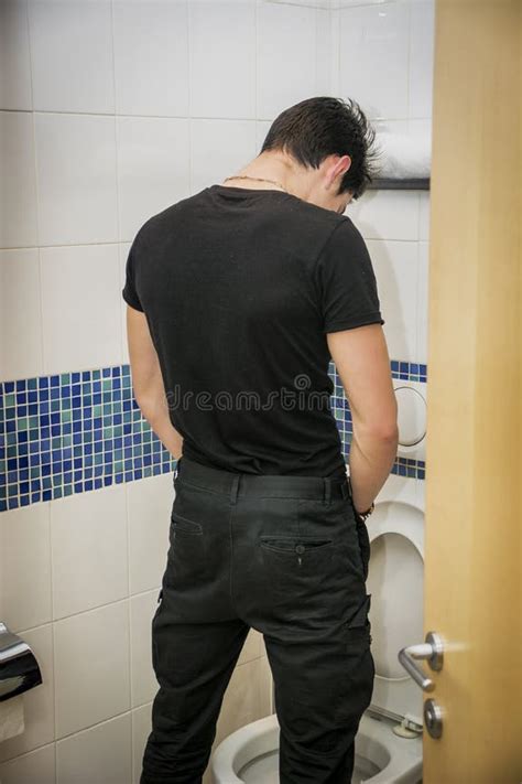 Rear View Of A Young Man Peeing At The Toilet Stock Image Image Of
