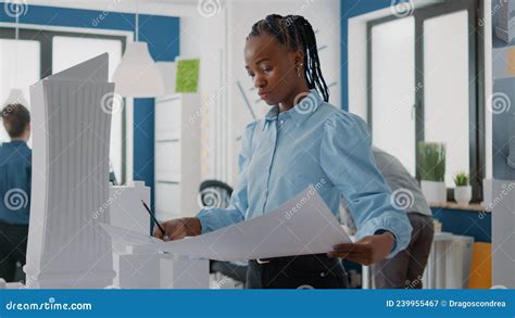 Woman Architect Analyzing Building Model And Blueprints Plans For Project Development Stock