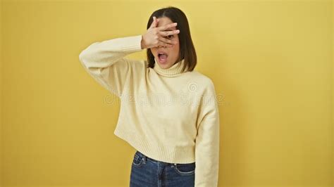 Shocked And Shy Beautiful Young Hispanic Woman In Sweater Peeking