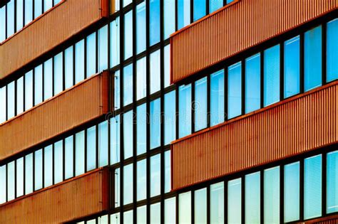Modern Building Facade With Vertical Metal Panels And Reflective Glass