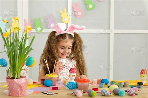 小女孩用复活节兔子耳朵在家里画复活节彩蛋。素材 花瓣网 小女孩用复活节兔子耳朵在家里画复活节彩蛋。素材 花瓣网